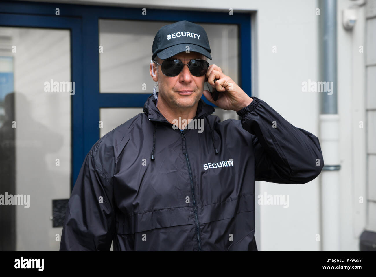 Confident Security Guard Using Mobile Phone Outside Building Stock ...