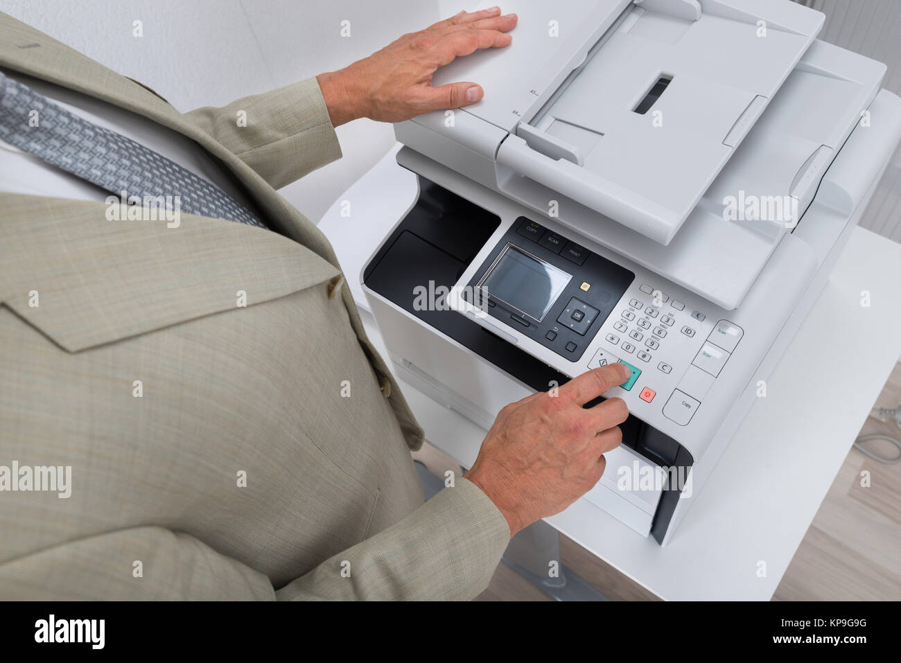 Businessman Pressing Printer's Button In Office Stock Photo - Alamy
