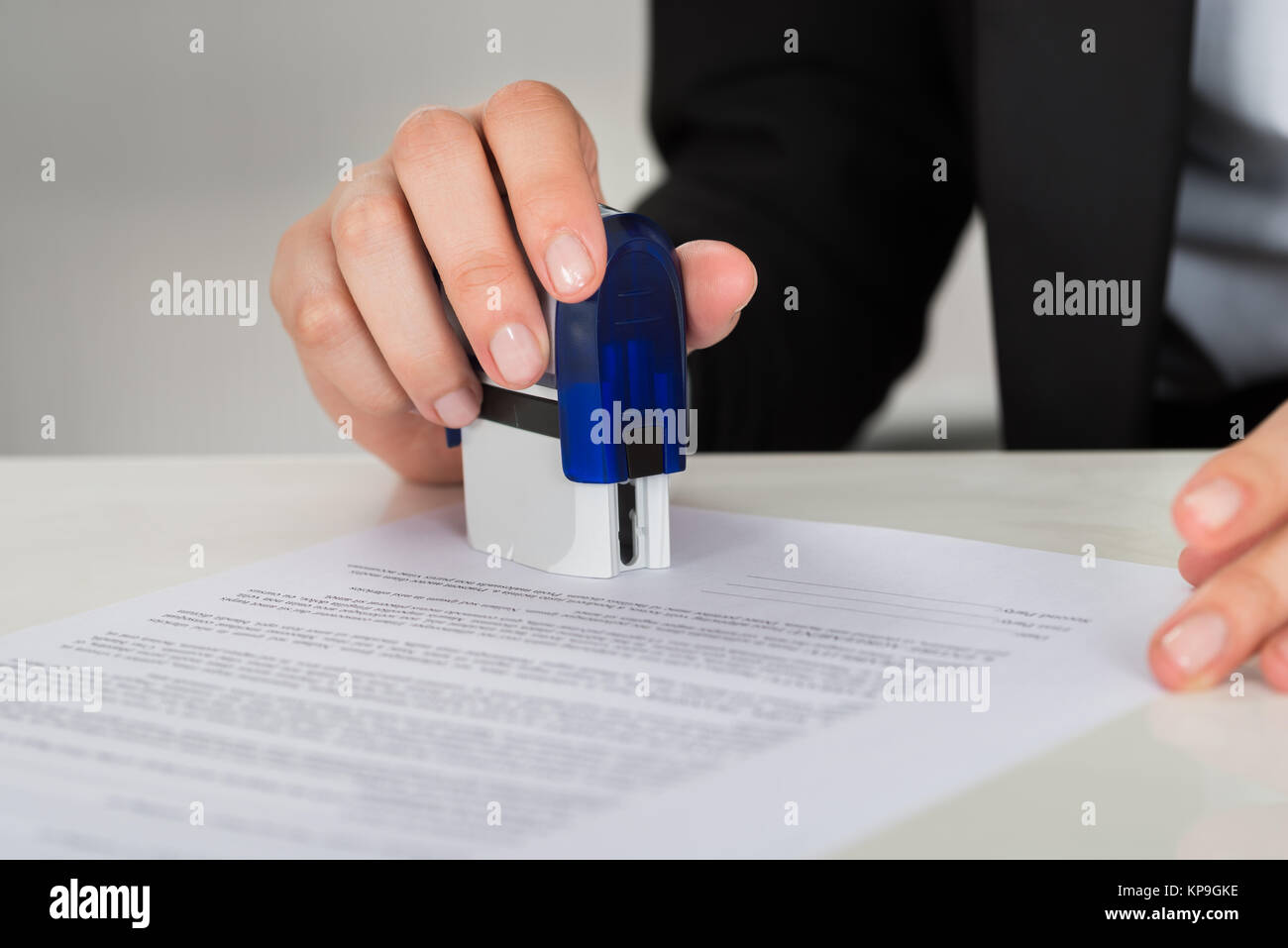 Businesswoman Stamping Contract Document At Desk Stock Photo - Alamy