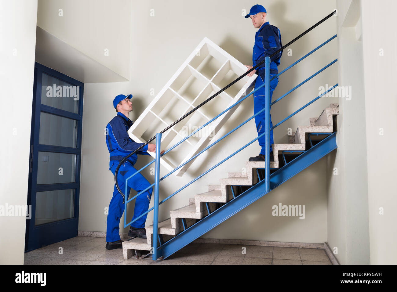 Movers Carrying Shelf While Climbing Steps Stock Photo - Alamy