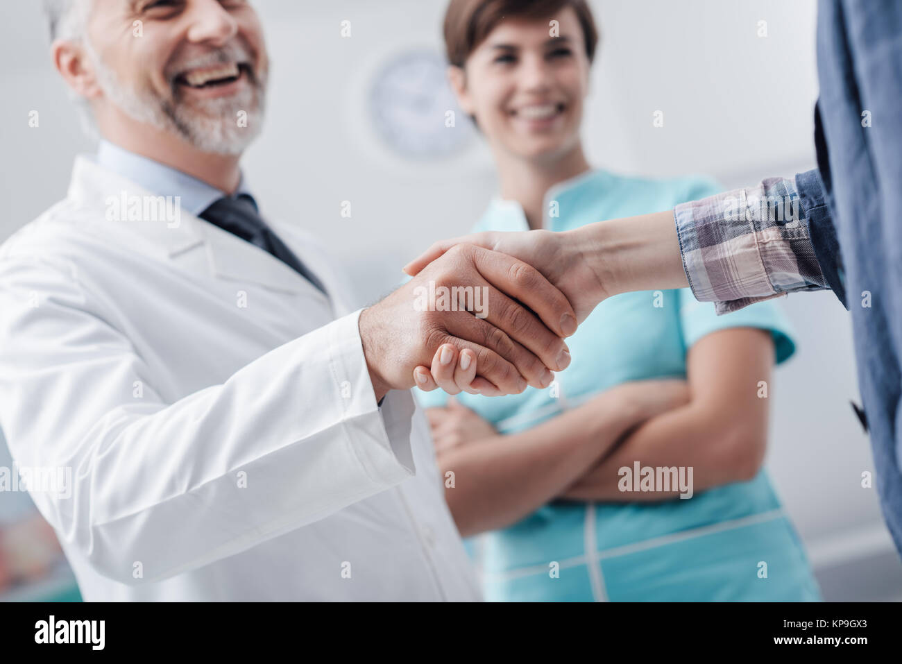 Medical staff welcoming a patient at the clinic: the doctor is giving ...