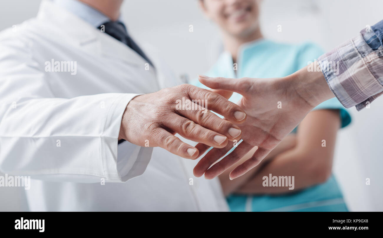 Medical staff welcoming a patient at the clinic: the doctor is giving ...