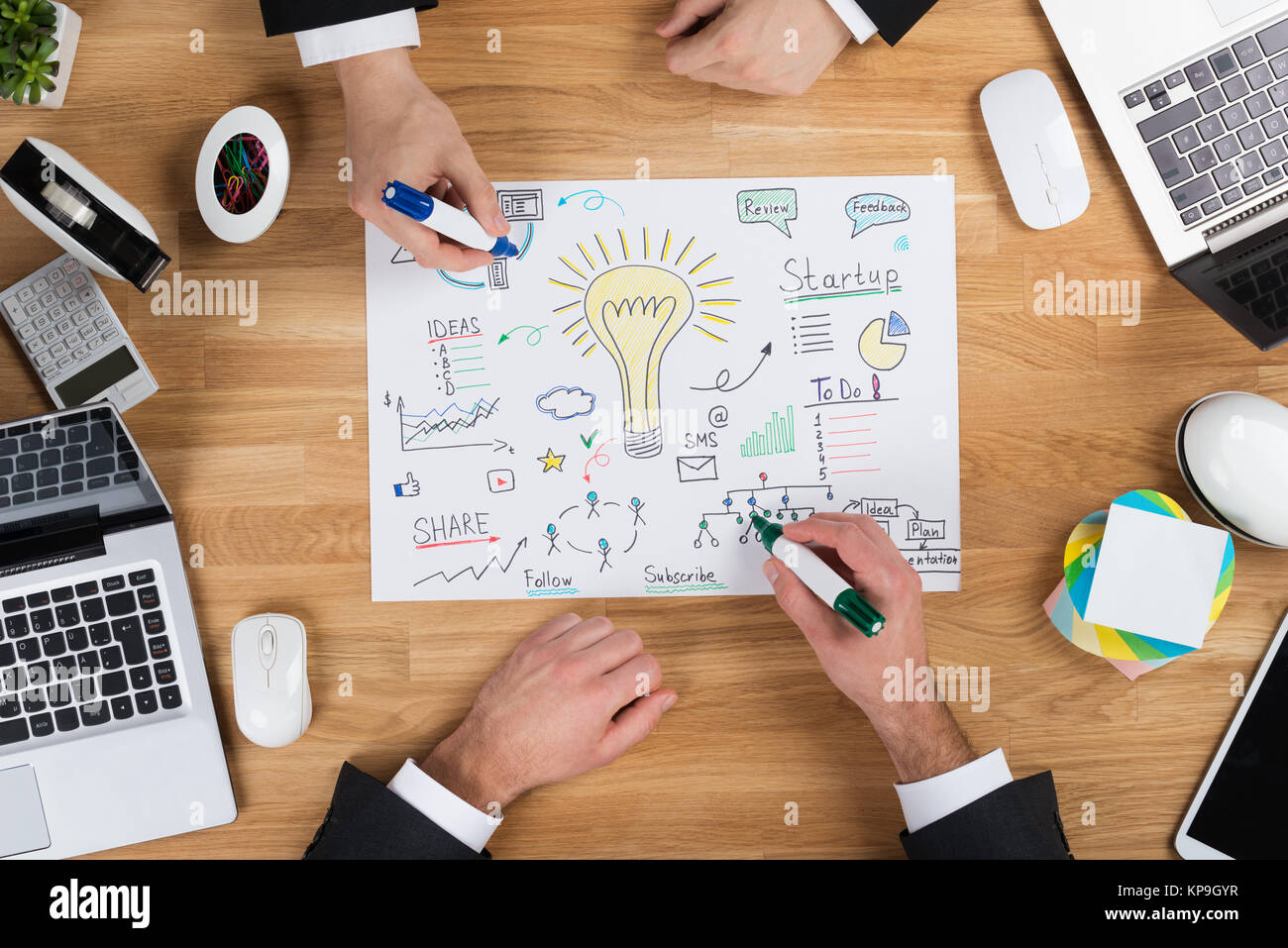 Businessmen Making Strategy At Wooden Desk Stock Photo - Alamy