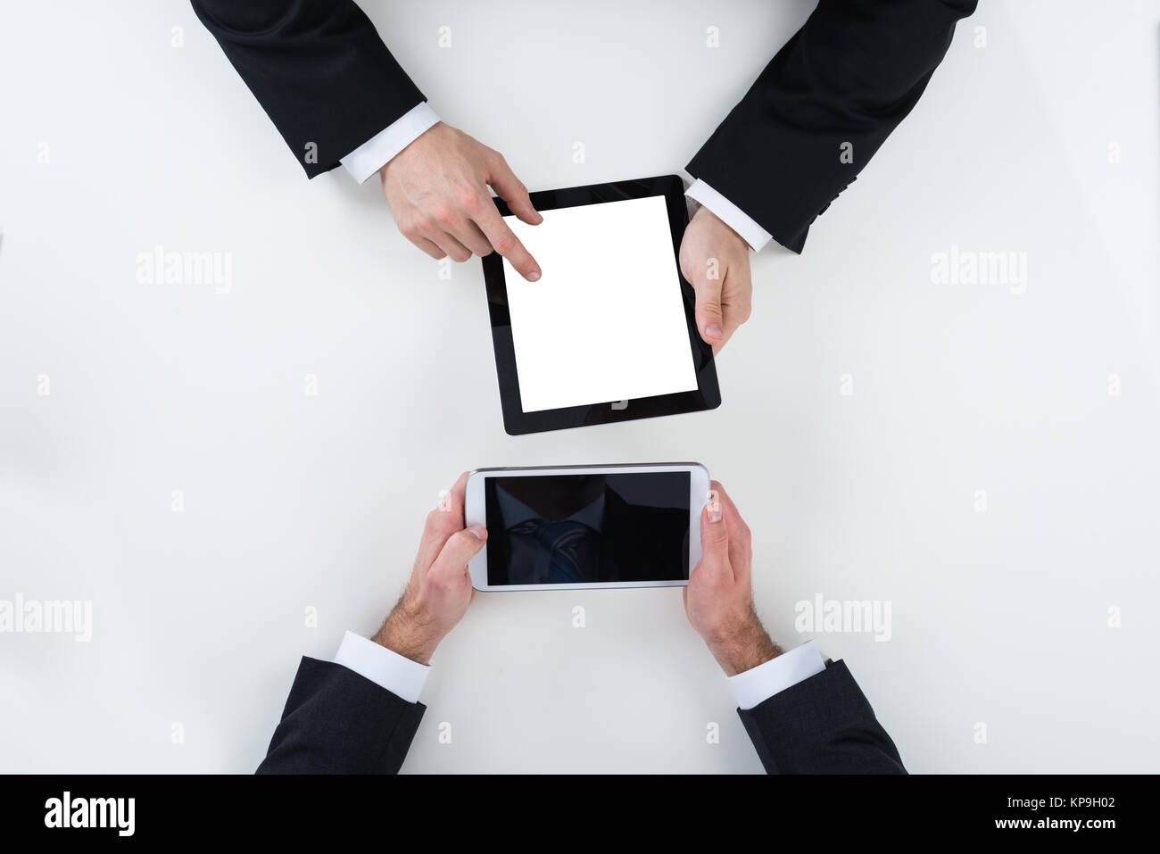Businessmen Using Digital Tablets At Table In Office Stock Photo - Alamy
