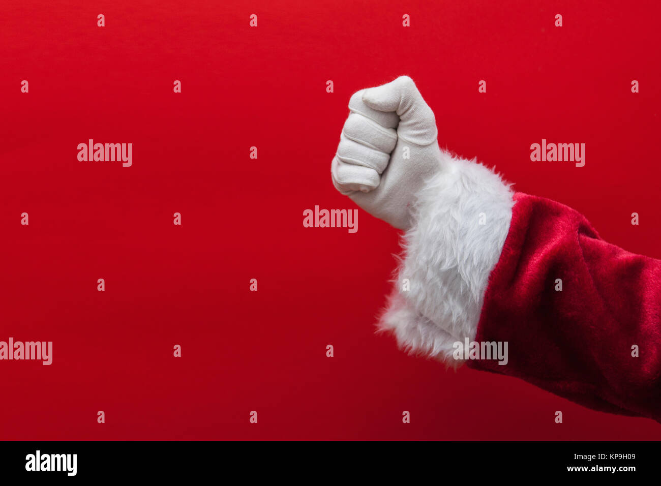 Santa Claus hand in fist against a red background Stock Photo - Alamy