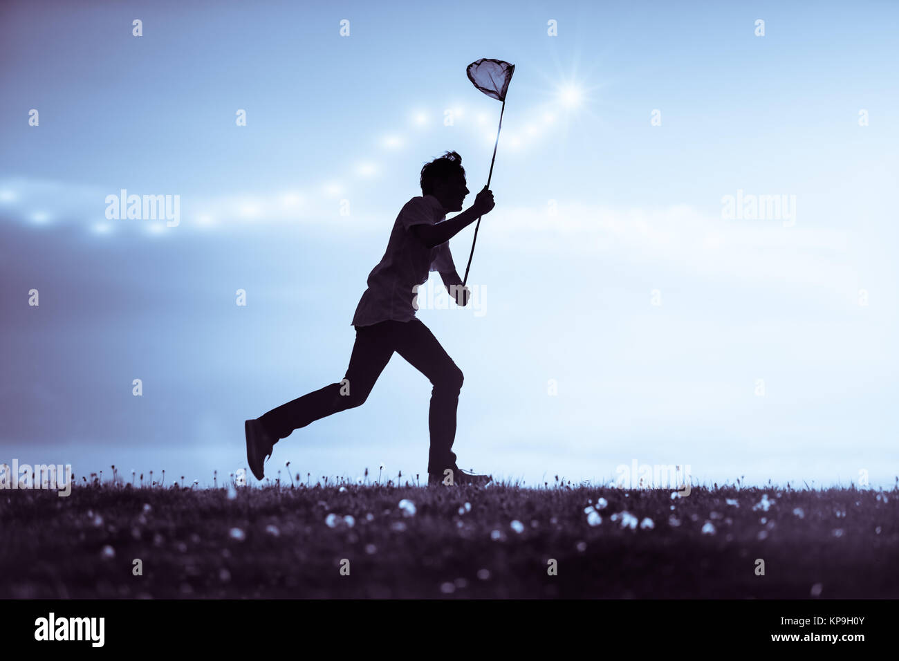 Young man catching insects at dusk Stock Photo - Alamy