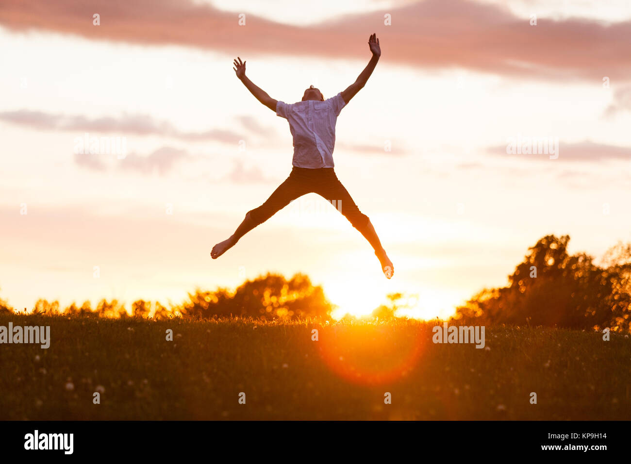 Boy Jumping High for Happiness Against Sunset Stock Photo - Alamy