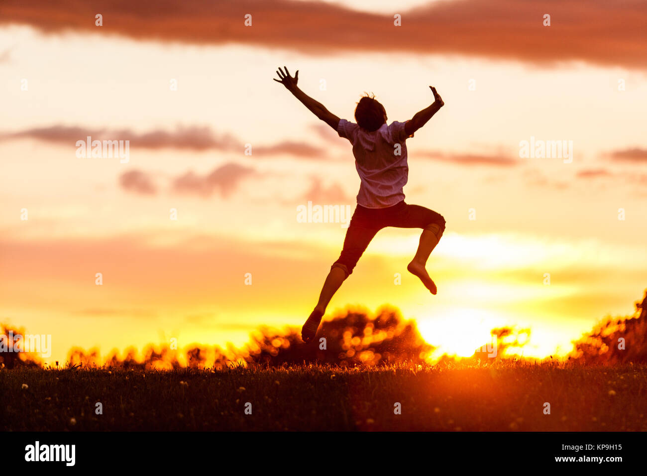 Rear View of a Happy Boy Jumping Against Sunset Stock Photo - Alamy