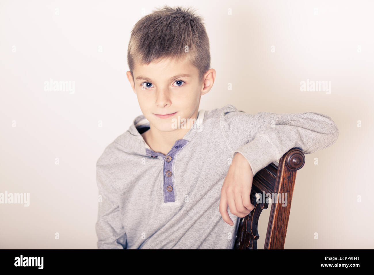 Seated Cute Boy Leaning Arm on the Back of a Chair Stock Photo - Alamy