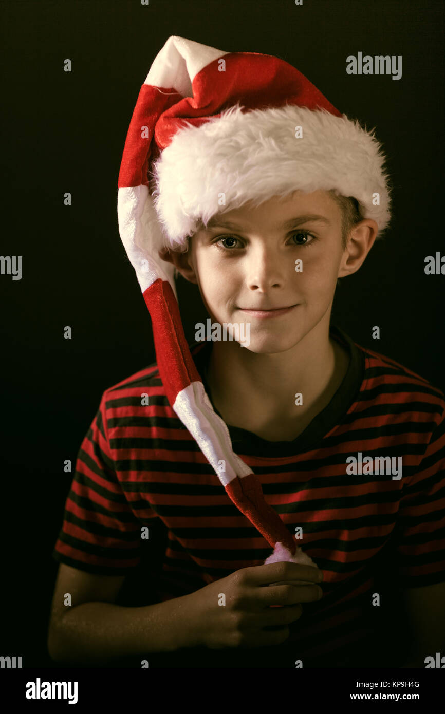 Young boy wearing a colorful striped Santa hat Stock Photo - Alamy