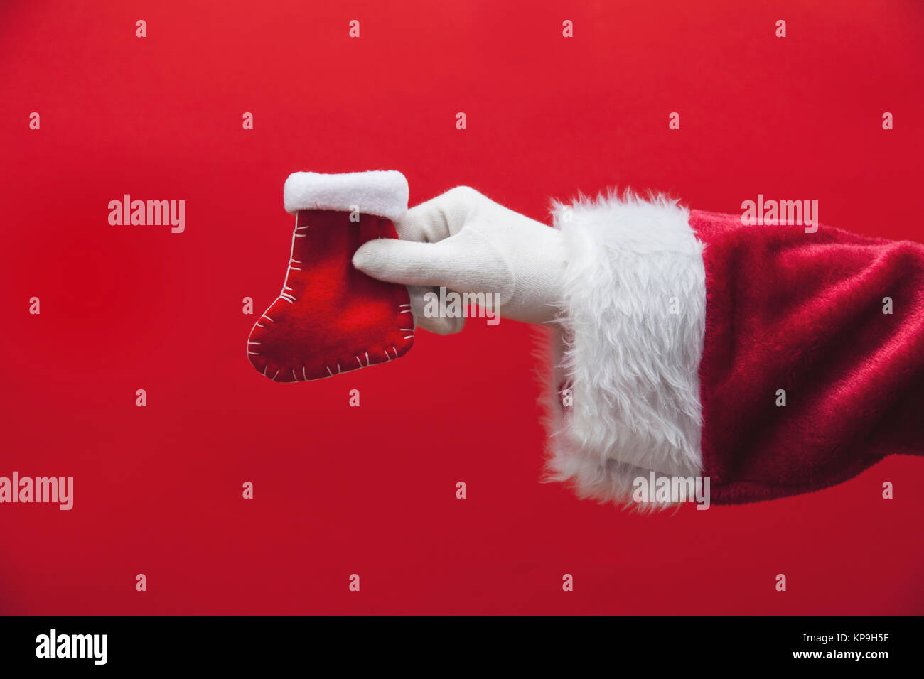 Santa Claus hand holding a Christmas stocking Stock Photo - Alamy