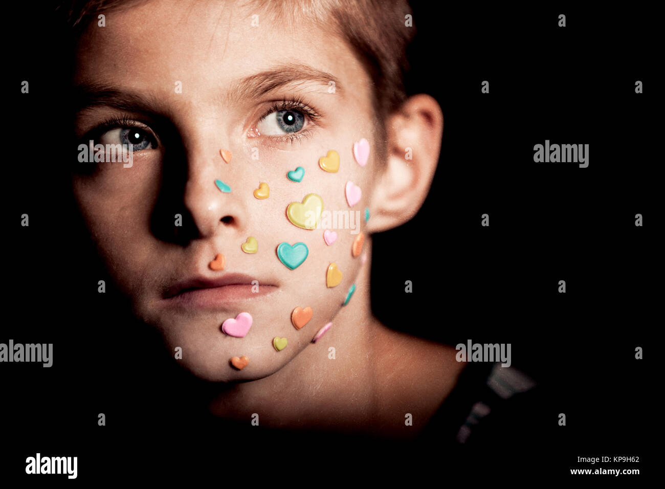 Boy with Hearts on Face Looking Into the Distance Stock Photo - Alamy