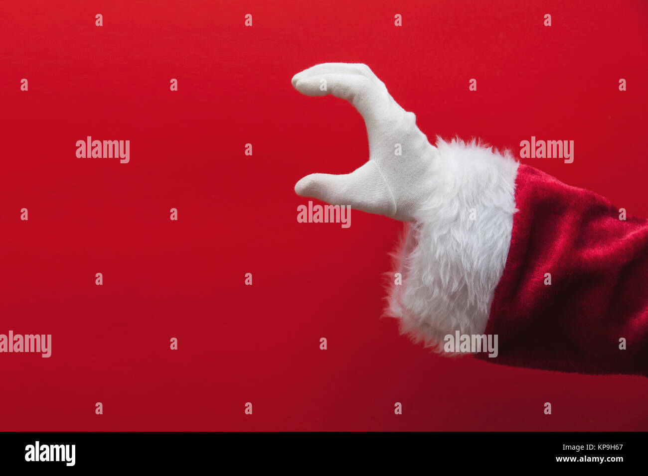 Santa Claus hand against a red background Stock Photo - Alamy