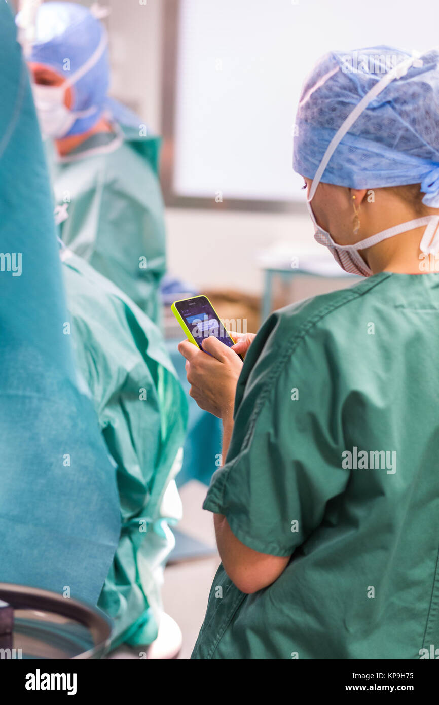 Nurse using a smartphone in an operating theater Stock Photo - Alamy