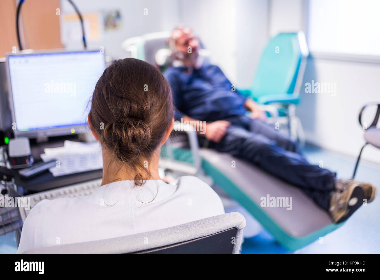 Man undergoing an electroencephalogram (EEG), epilepsy screening ...