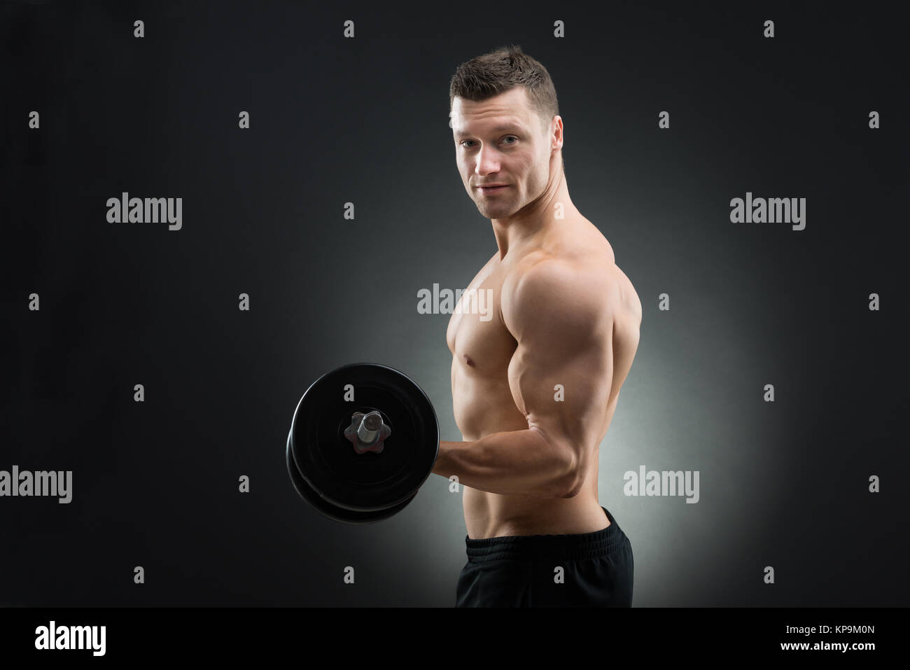 Confident Muscular Man Lifting Dumbbell Stock Photo - Alamy