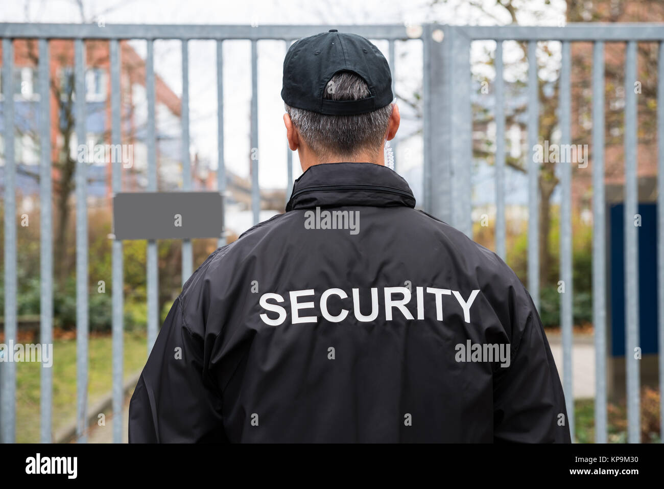Security Guard Standing In Front Of Gate Stock Photo - Alamy