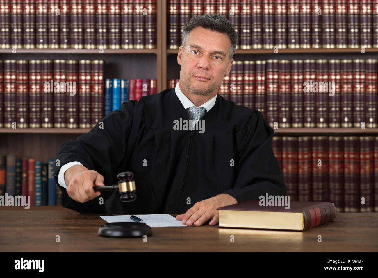 Confident Judge Striking The Gavel At Table Stock Photo - Alamy