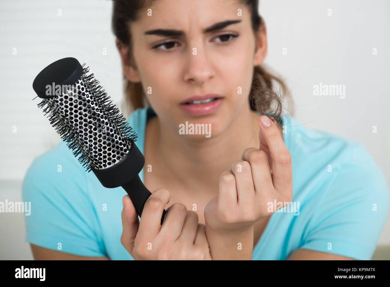 Woman Holding Comb While Looking At Hair Loss Stock Photo - Alamy