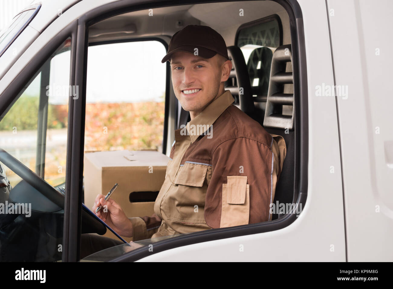 Delivery Man Making Checklist In Truck Stock Photo - Alamy
