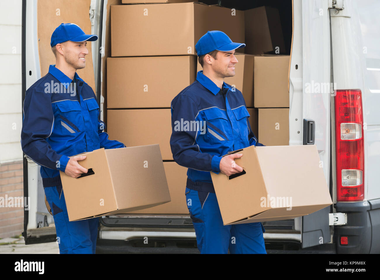 Delivery Men Carrying Cardboard Boxes Stock Photo - Alamy