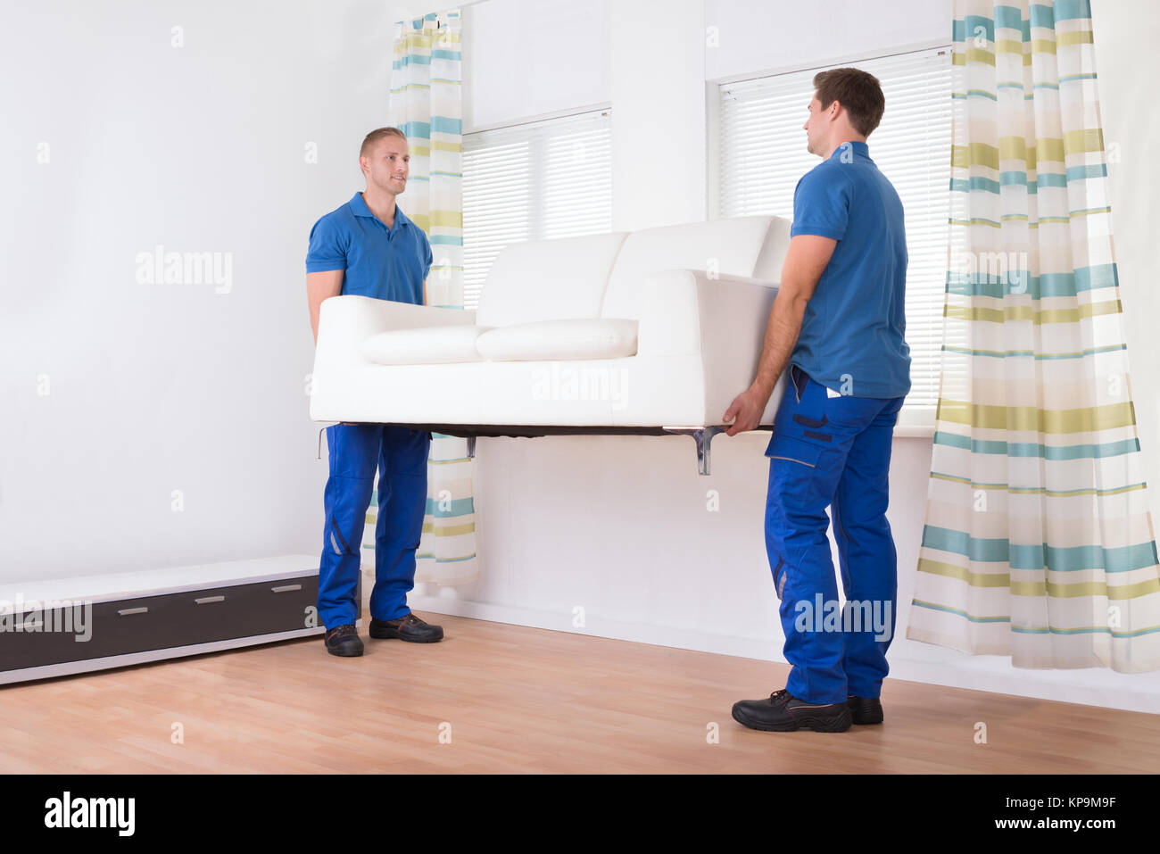Movers Carrying Sofa At Home Stock Photo - Alamy