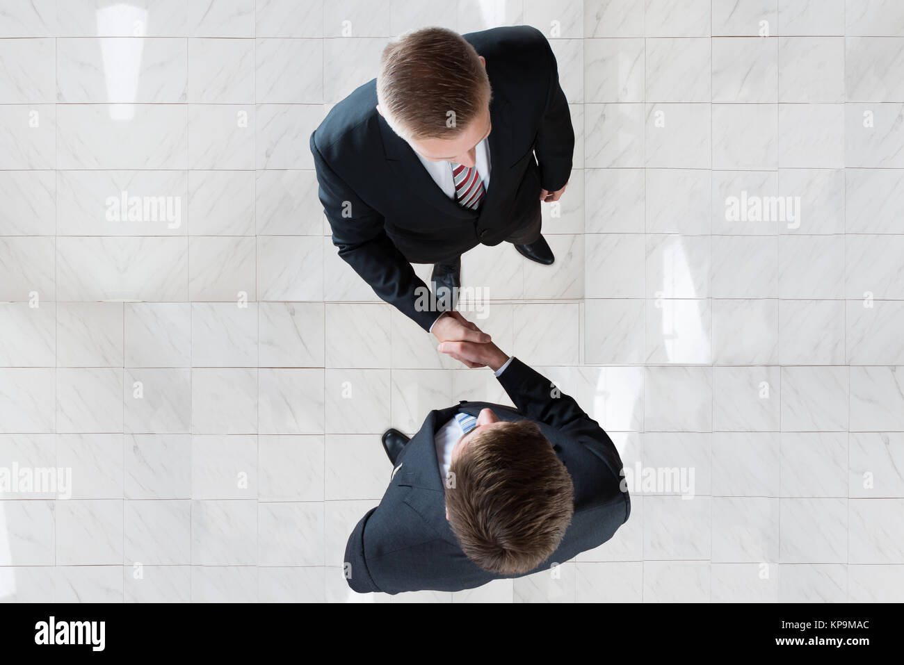 Businessmen Shaking Hands In Office Stock Photo - Alamy