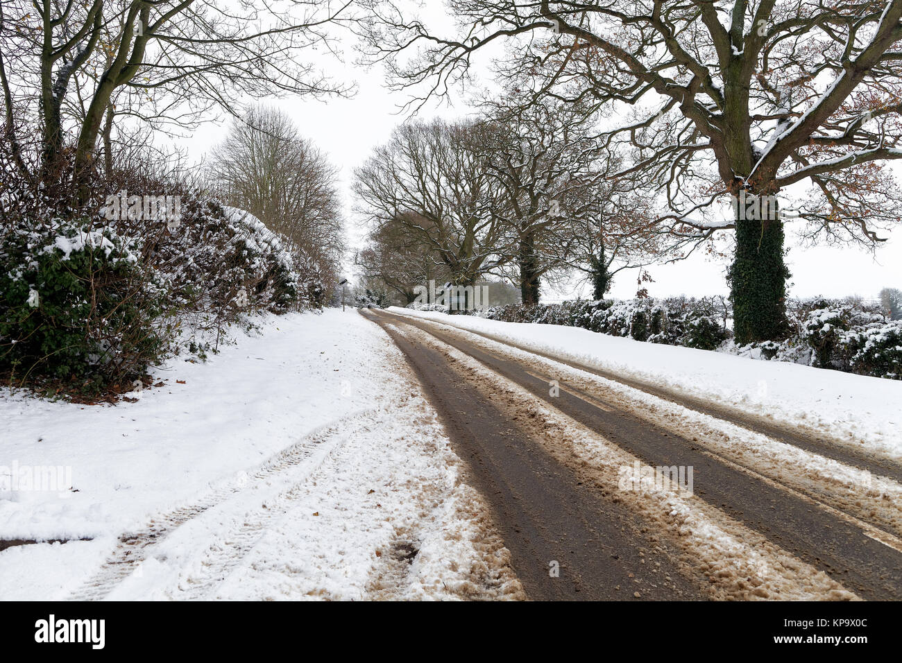 Snow covered road through winter countryside Stock Photo - Alamy