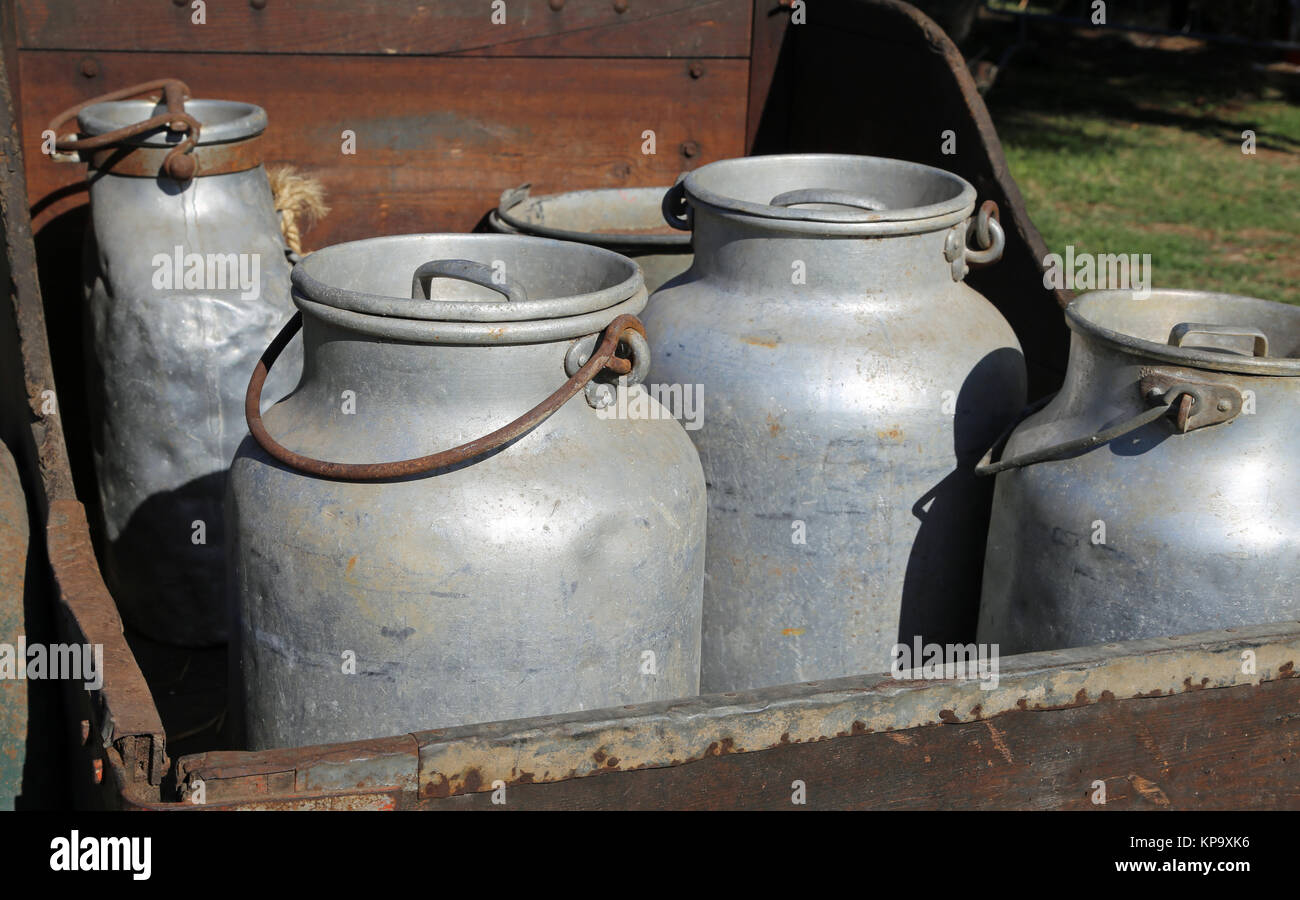 many aluminum milk cans in the wooden cart Stock Photo - Alamy