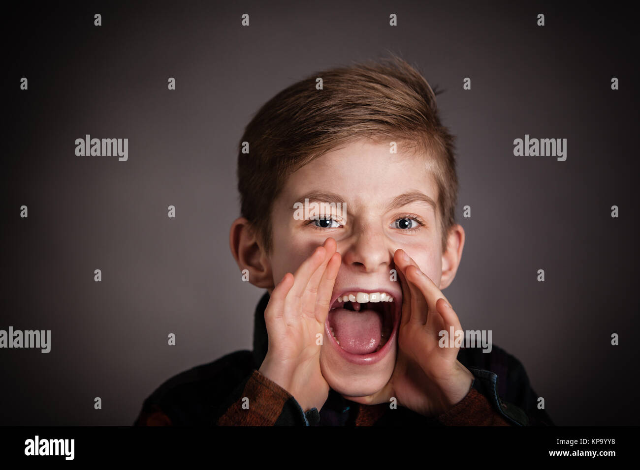 Handsome Boy Screaming at the Camera Against Gray Stock Photo - Alamy