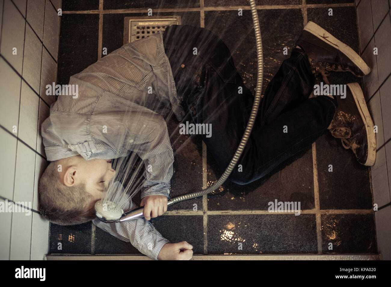 Boy Holding Shower Head Collapsed in the Rest Room Stock Photo - Alamy