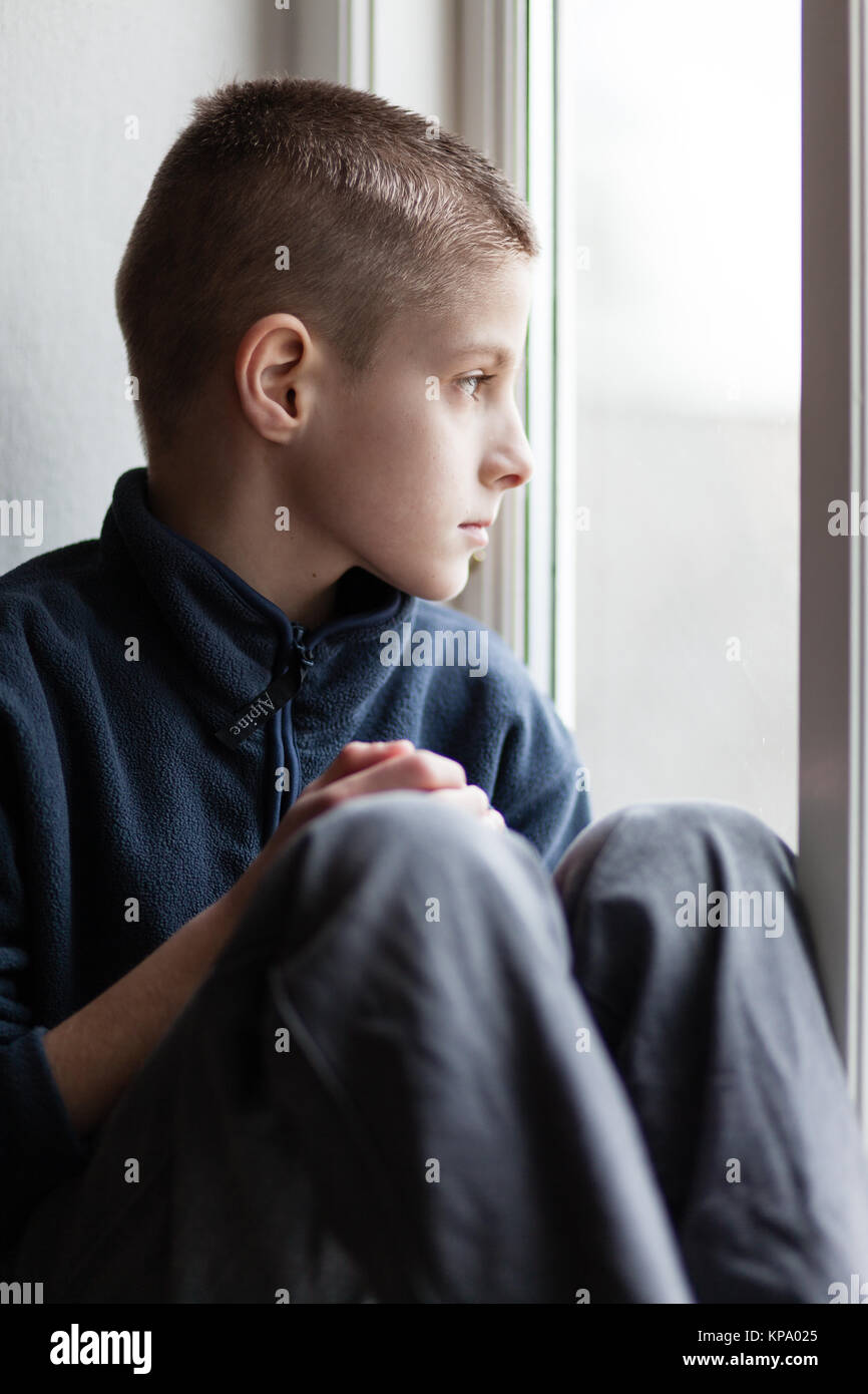 Lonely Orphan Boy Sitting at the Glass Window Stock Photo - Alamy