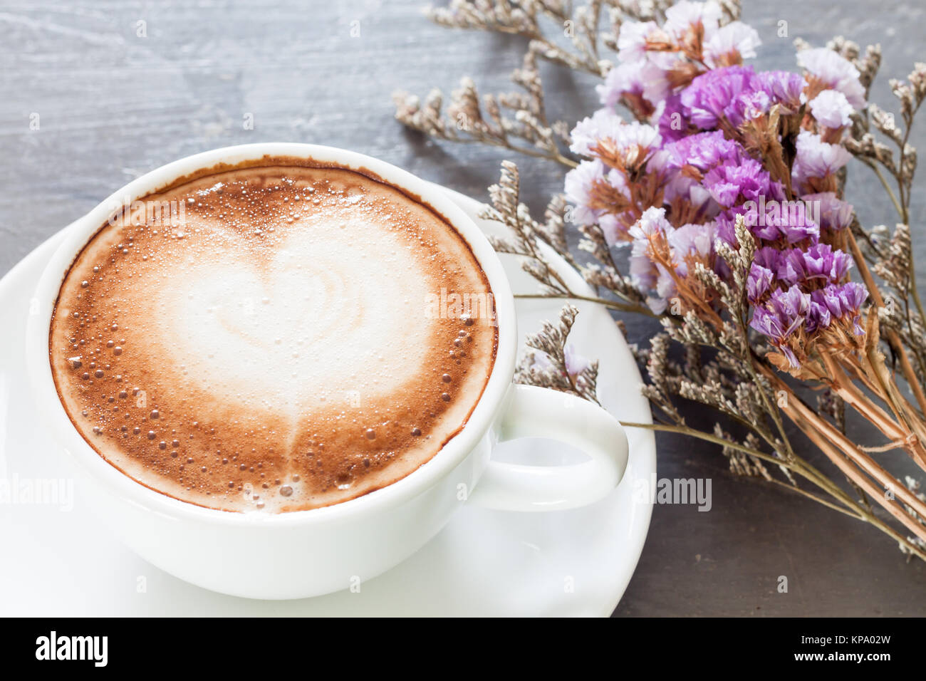 Coffee cup with beautiful violet flower Stock Photo - Alamy