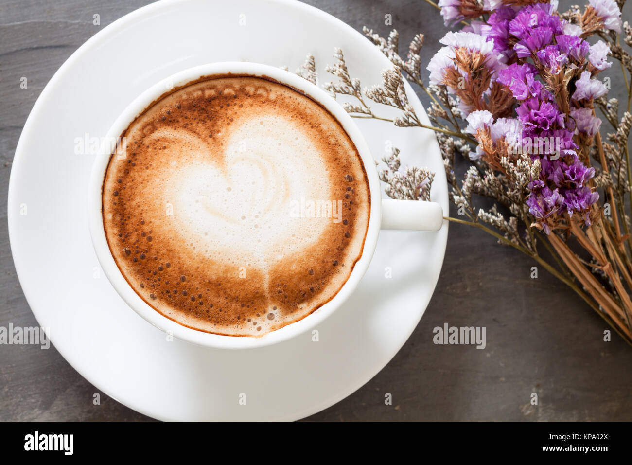 Coffee cup with beautiful violet flower Stock Photo - Alamy