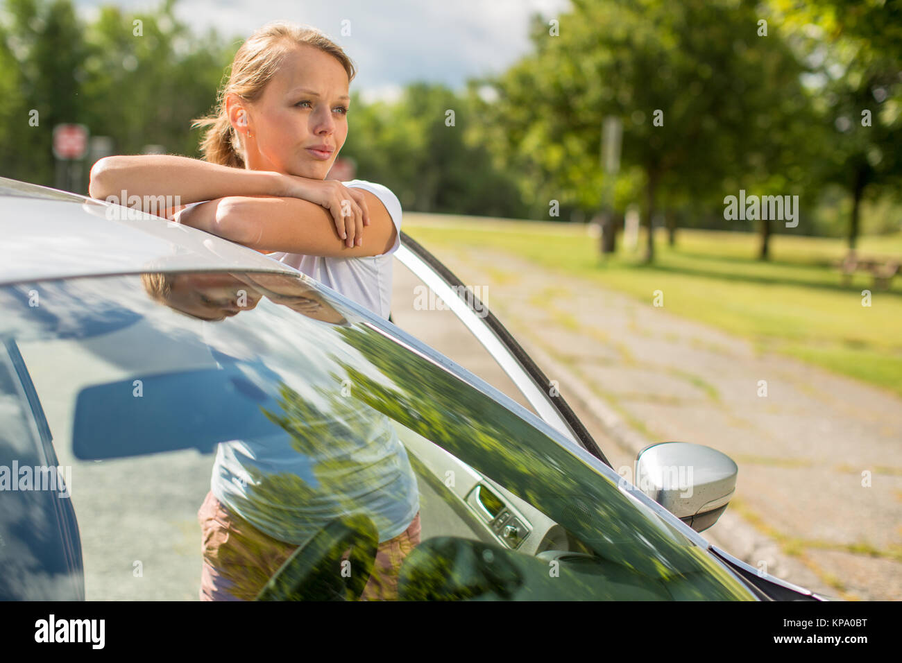 Young woman standing by her new car Stock Photo - Alamy