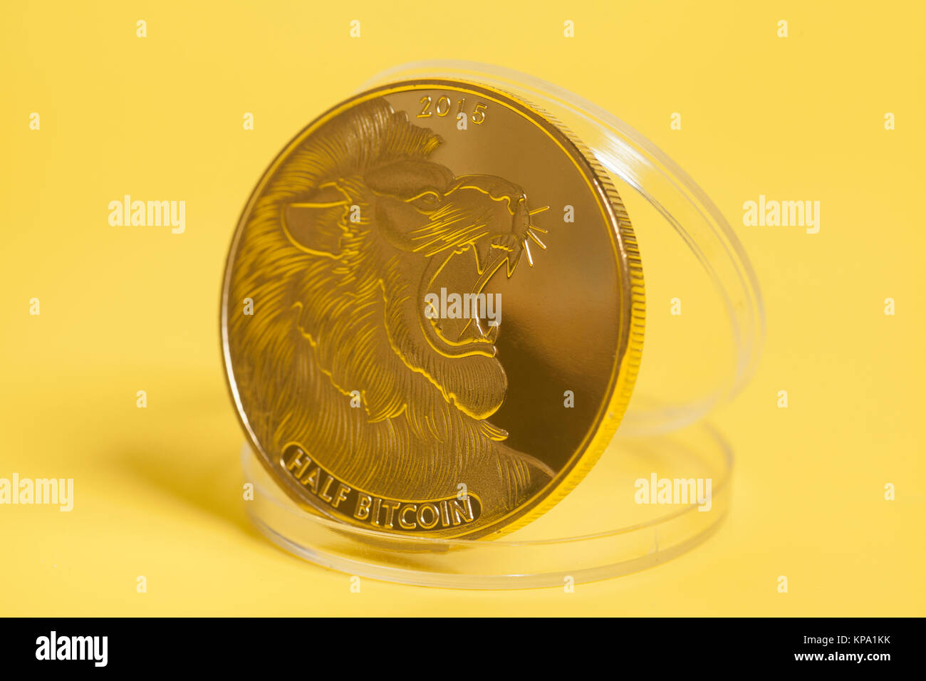 Half bitcoin with lion on a yellow background Stock Photo - Alamy