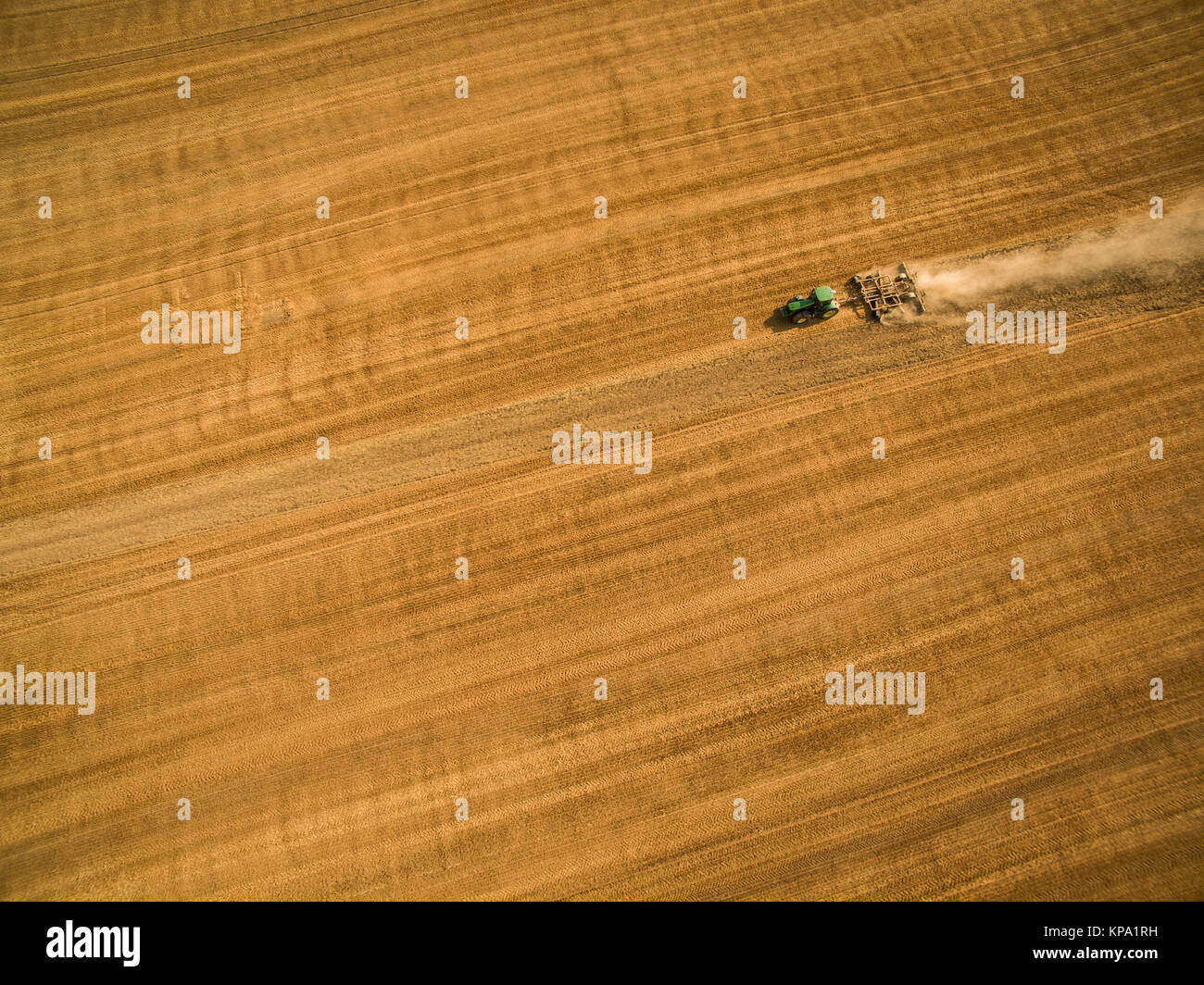 Aerial view of a tractor working a field after harvest Stock Photo - Alamy