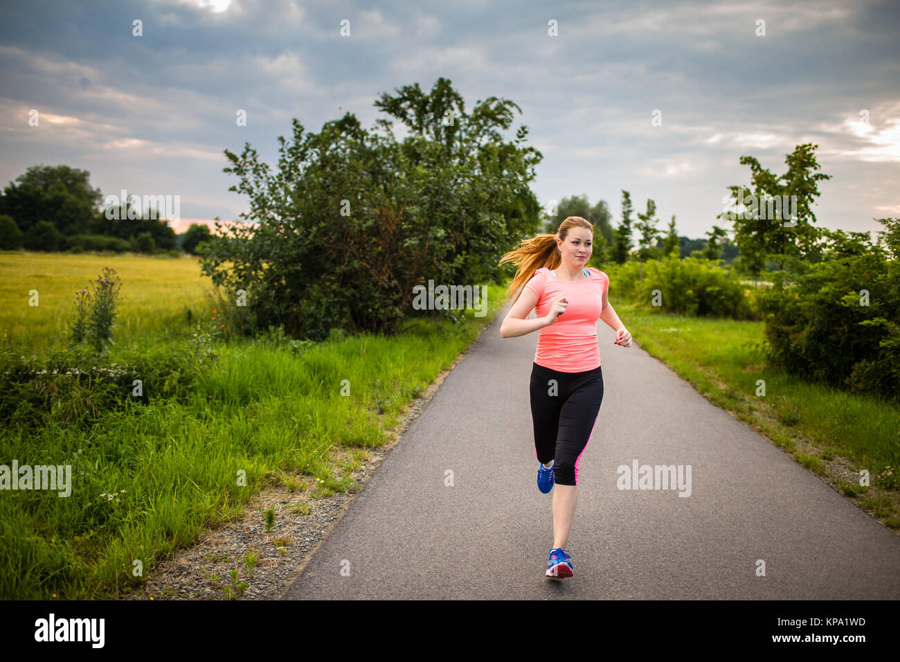 Young woman running outdoors on a lovely sunny winter/fall day Stock ...