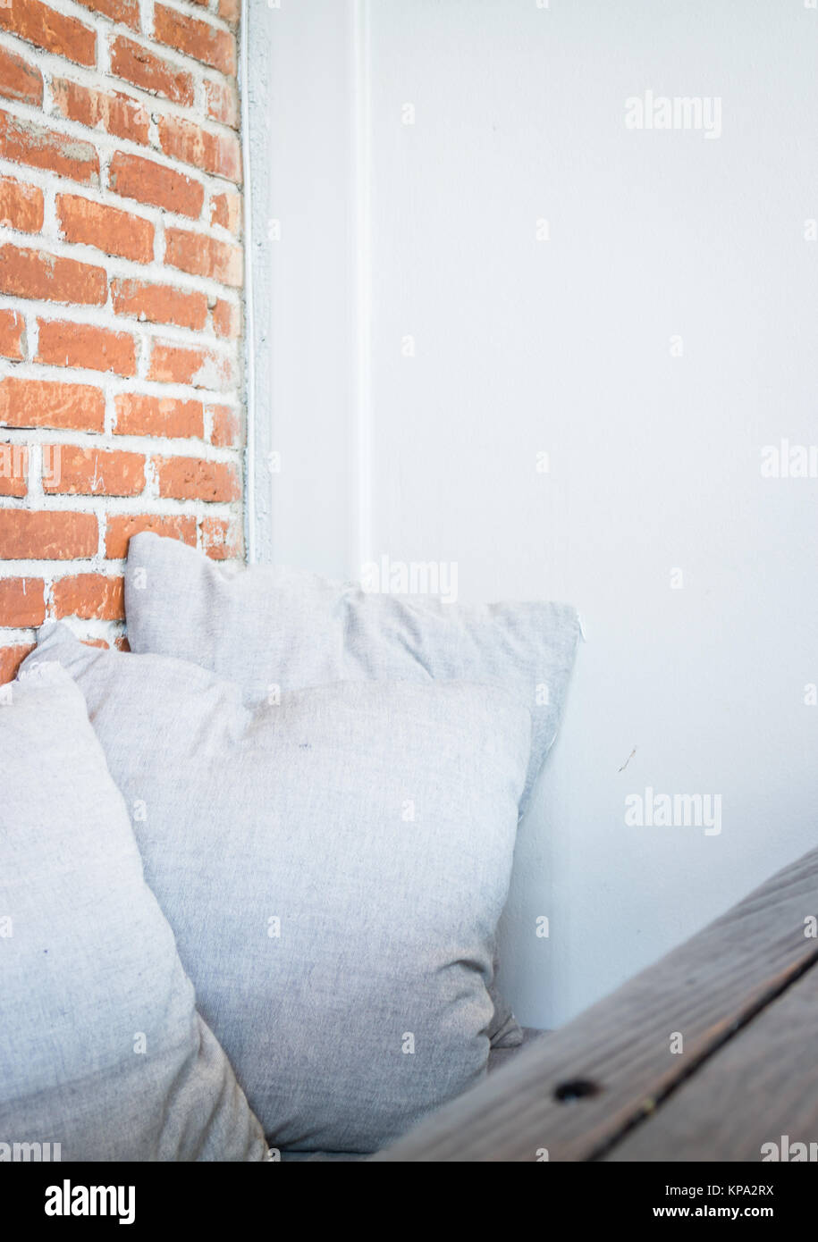 Grey pillow on a brick wall background Stock Photo - Alamy