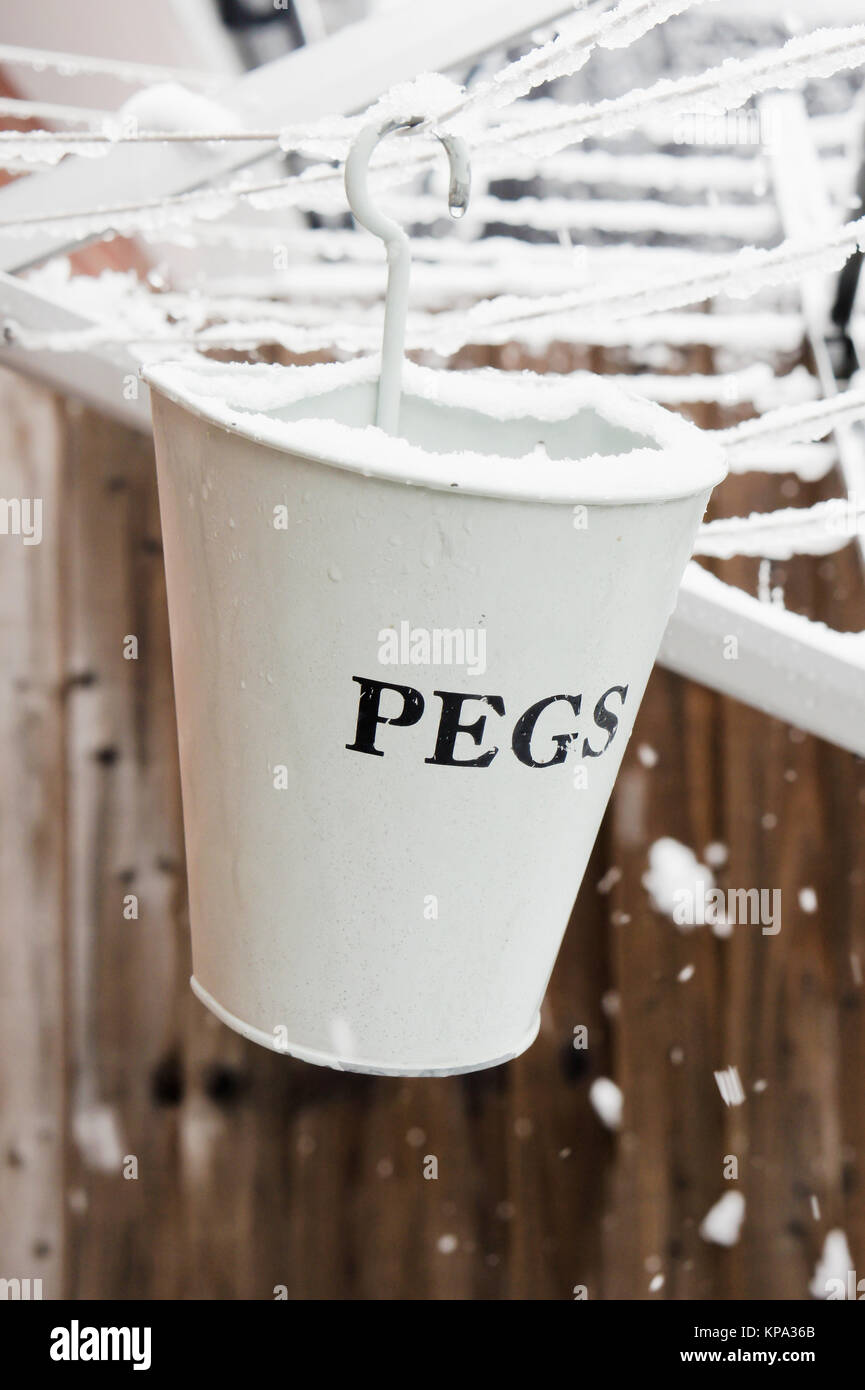 A peg tin hanging an a clothes line in the snow Stock Photo - Alamy