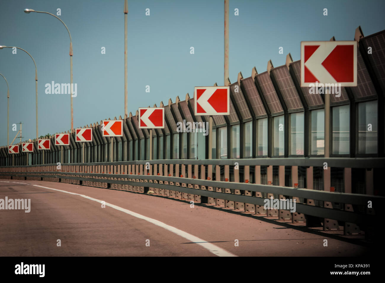 Signs pointing to a prolonged turn is fixed on the protective barrier ...