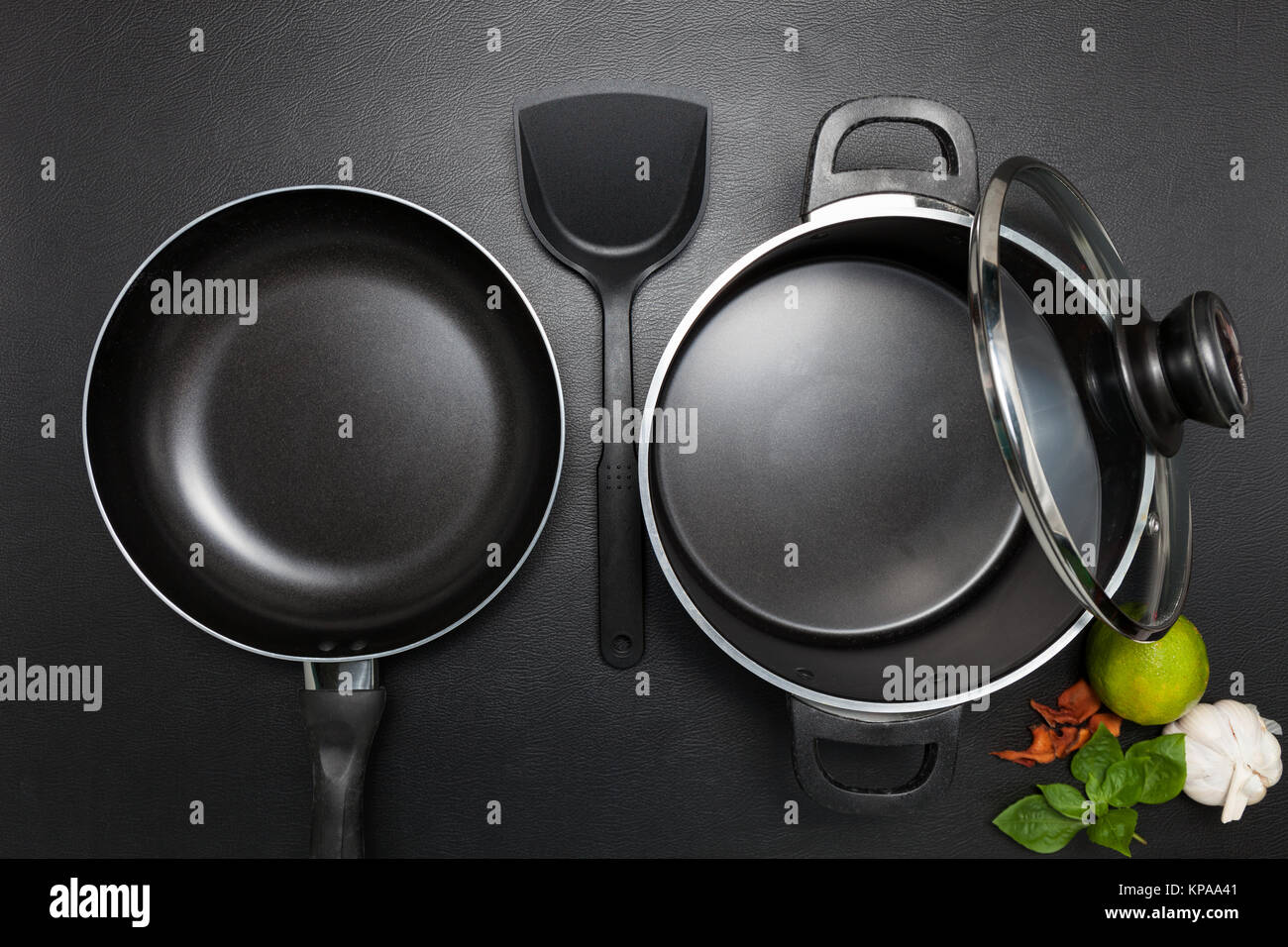 Top view frying pan and pot on black table Stock Photo - Alamy