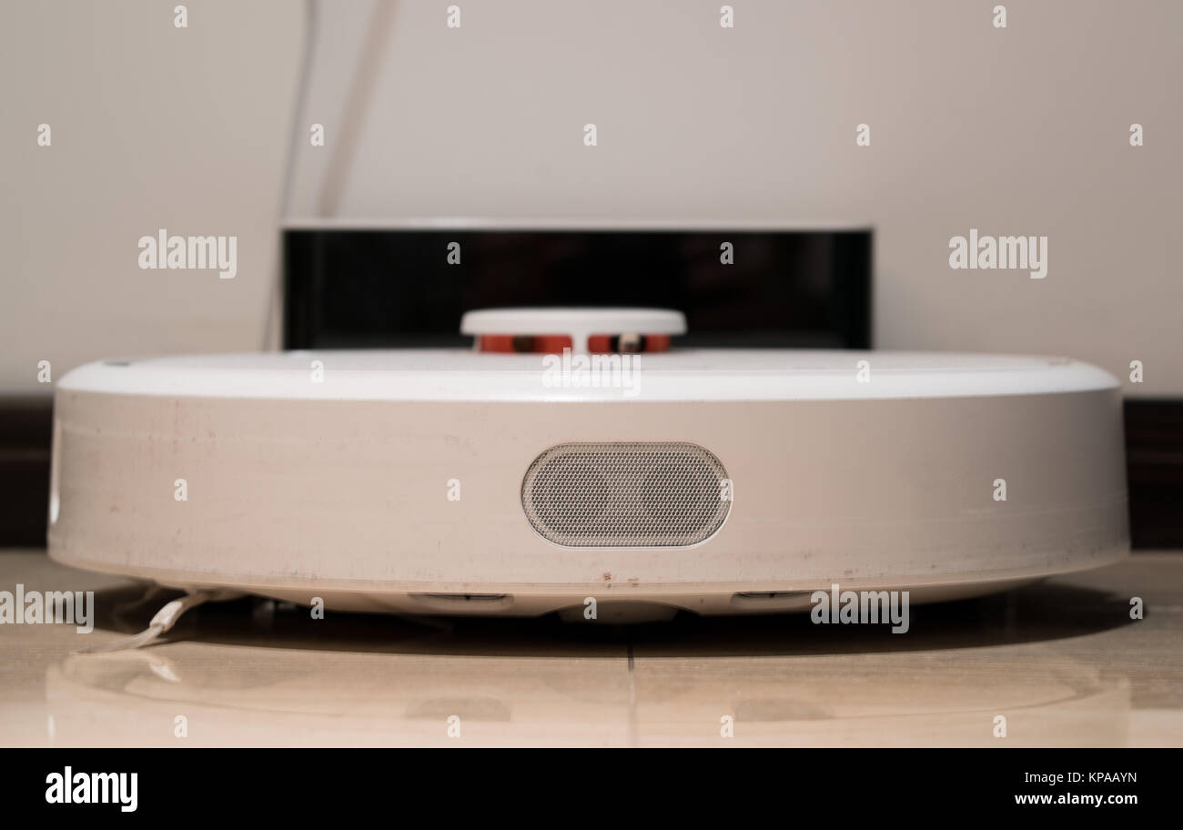 Generic white robotic vacuum cleaner front view recharging on the base ...