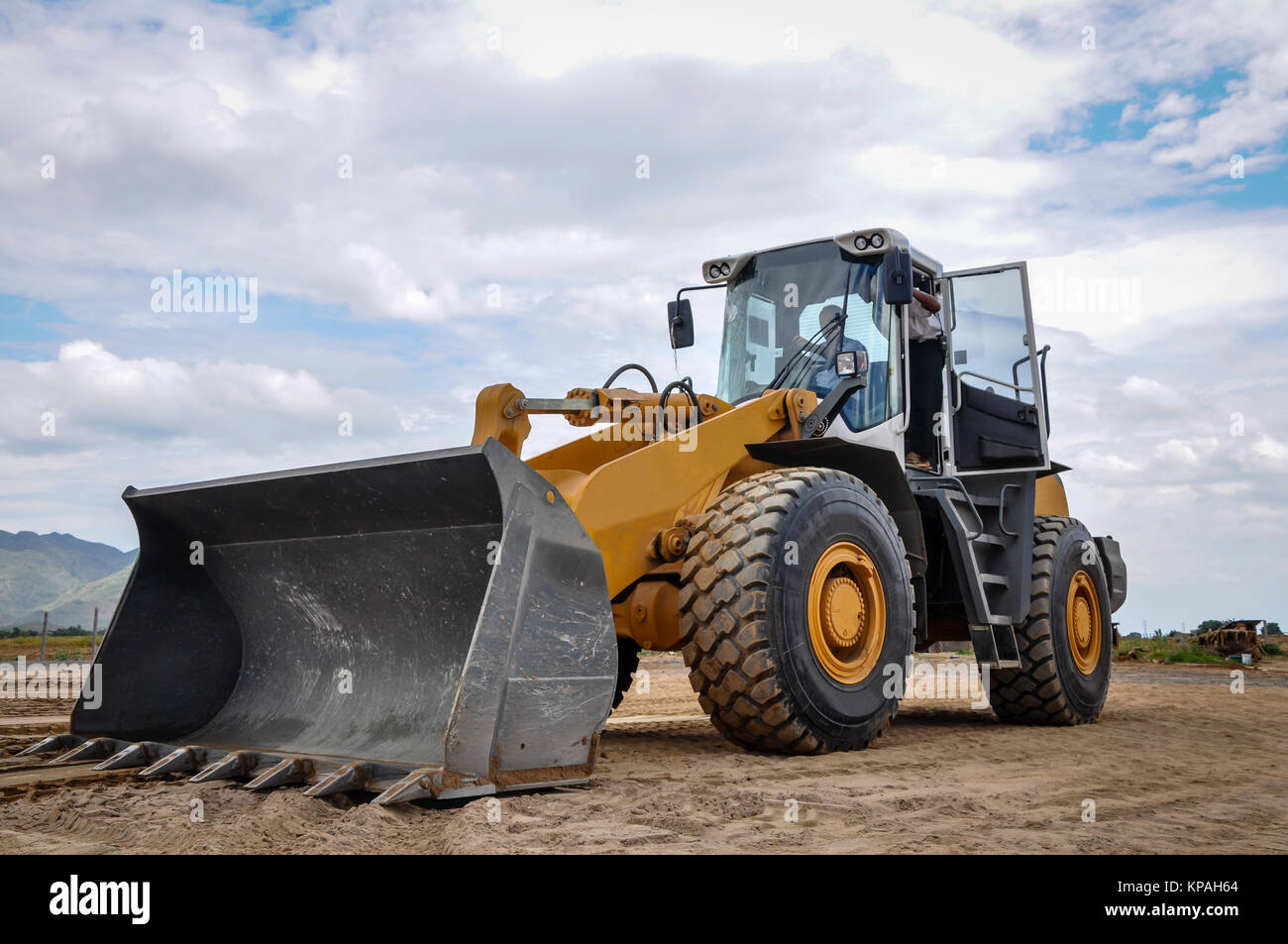 landscape photo of wheel loader in construction site with cloudy sky ...
