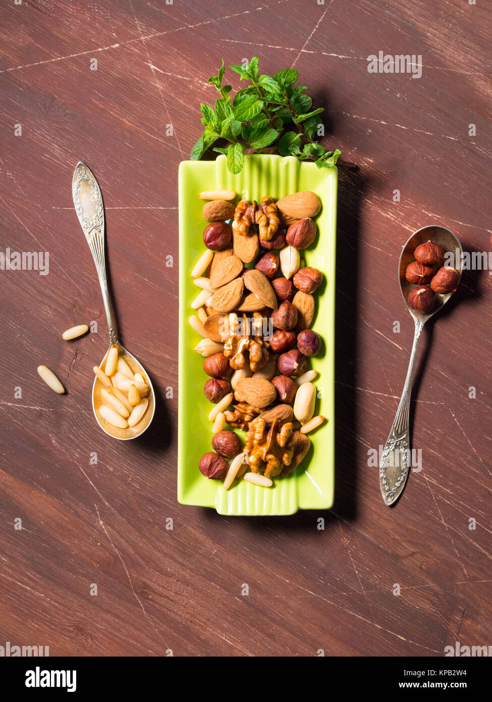 Nut mix on green dish - walnuts, pine nuts, peanuts, hazelnuts Stock ...