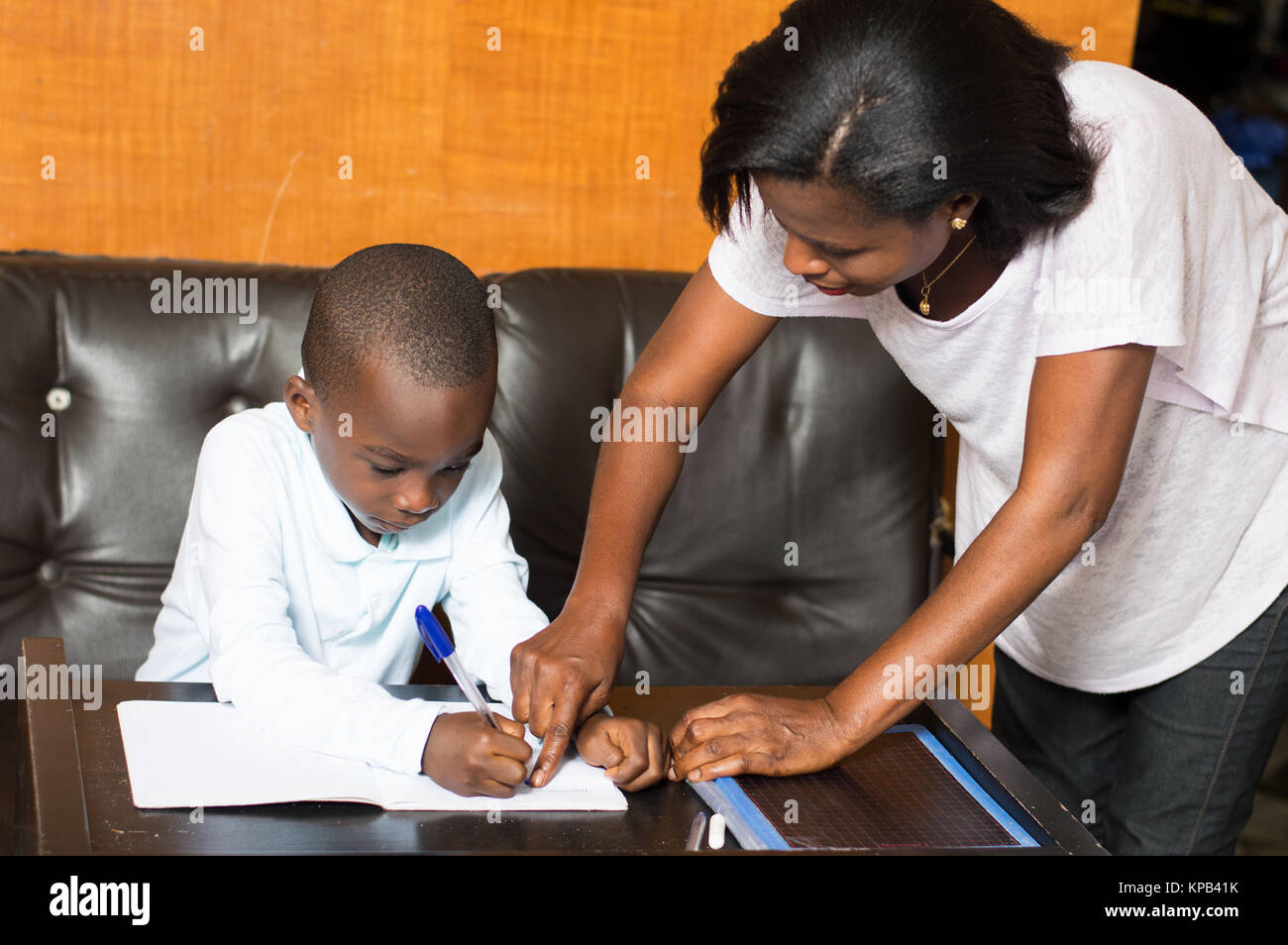 Mom shows her child where he has to write in his notebook Stock Photo ...