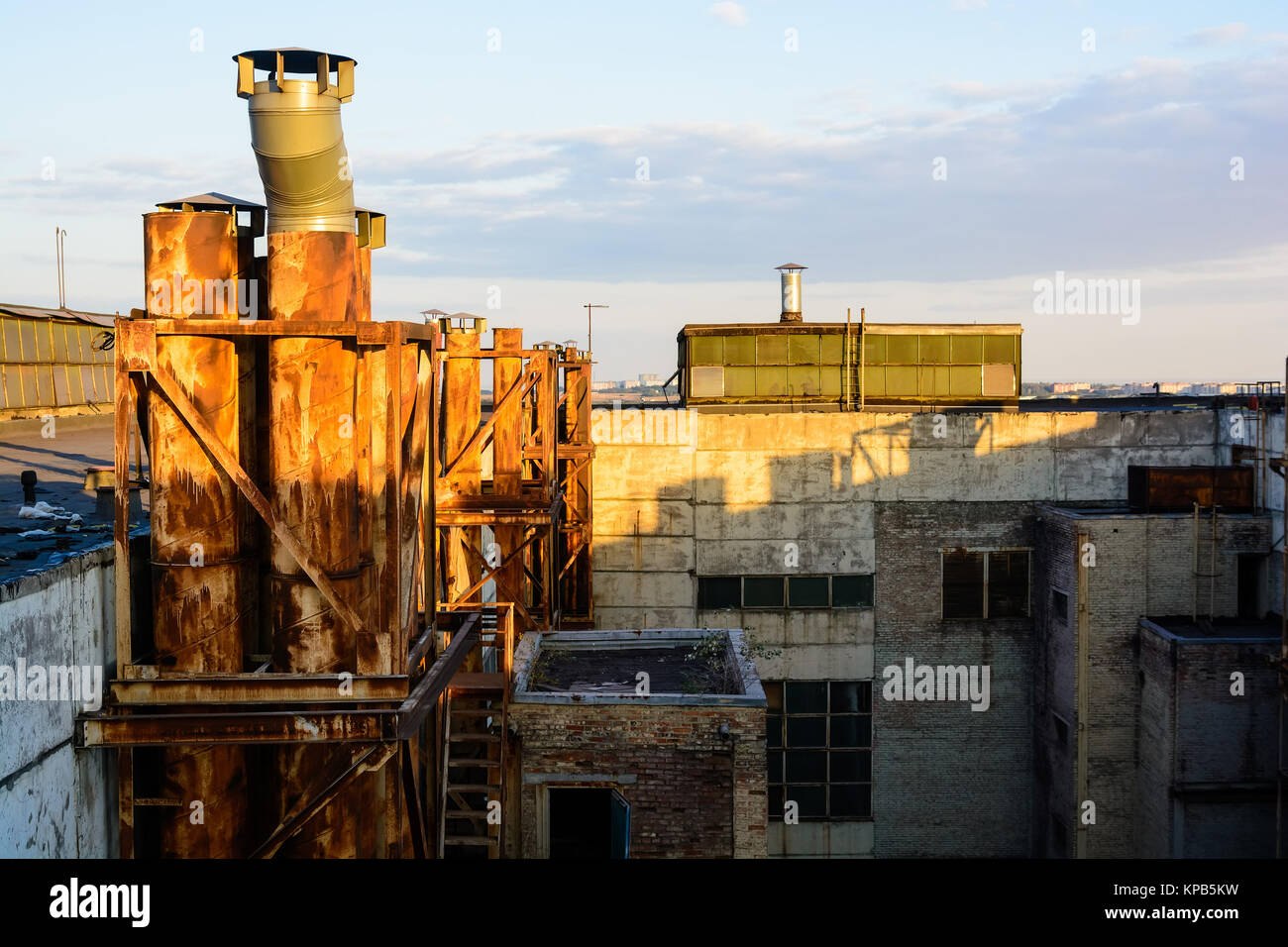 Rooftops of industrial buildings with pipes and staircases in a big ...
