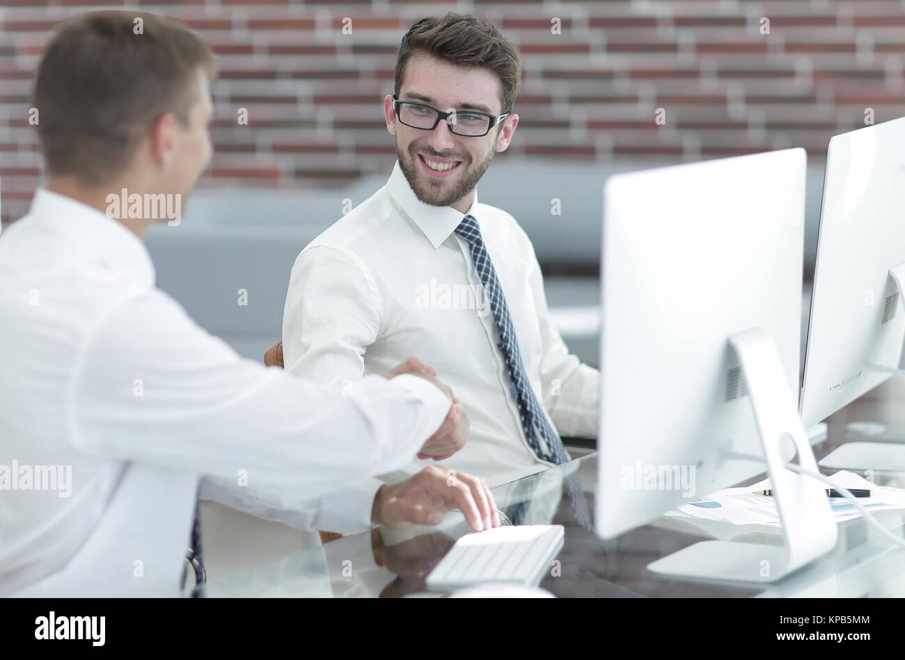 handshake of the employees at the Desk Stock Photo - Alamy