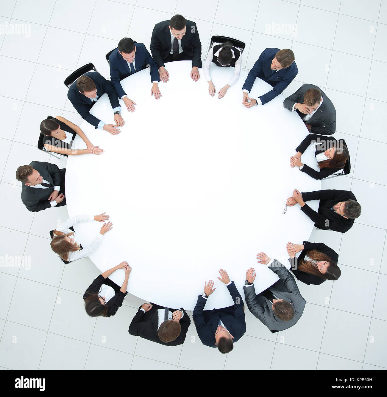 coach leads the session with business team sitting at a round table ...