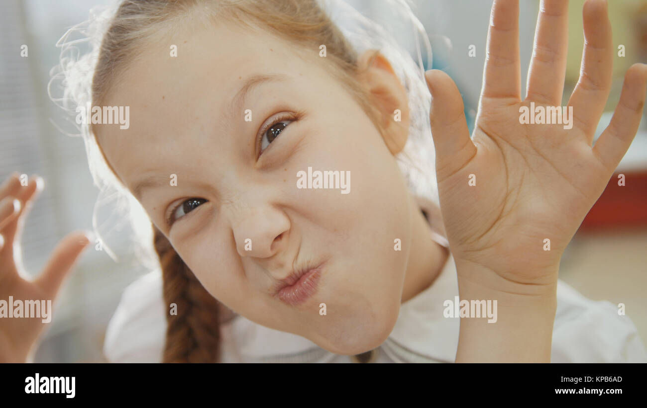 Little girl have funny and shows into camera piglet nose and tongue ...